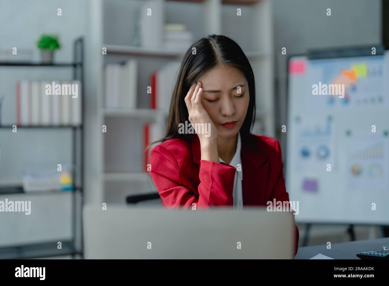 Portrait of a young Asian woman showing acute headache from sitting for ...