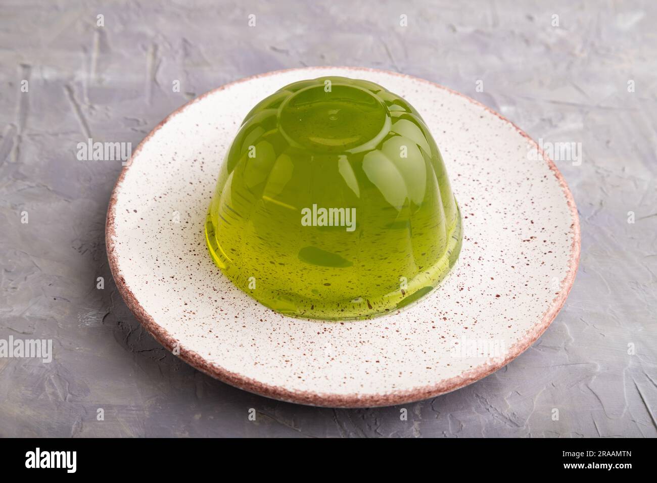 Mint and raspberry green jelly on gray concrete background. side view ...