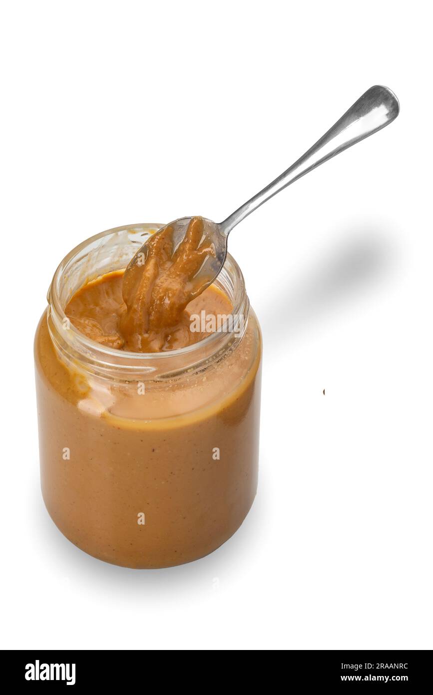Peanut butter in an open glass jar top view with teaspoon, isolated on ...
