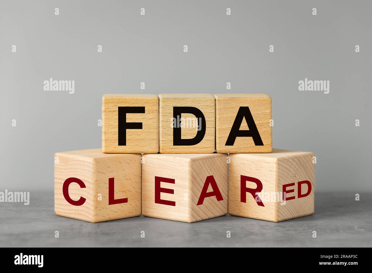 FDA cleared, words on wooden blocks. Beautiful gray background ...
