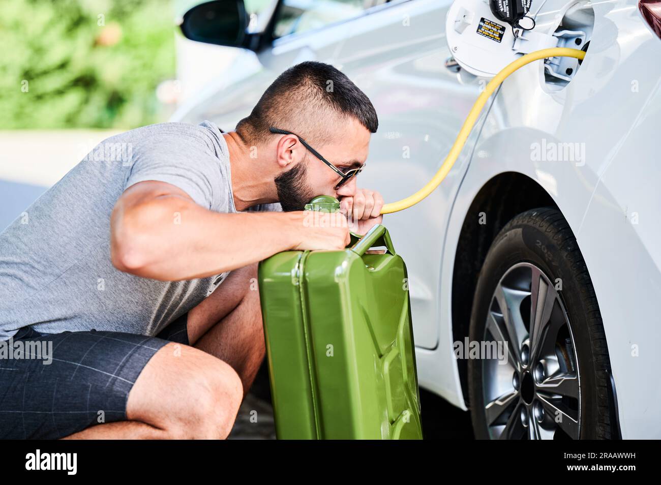 Weird man pumping gasoline from a gas tank into canister. Self ...