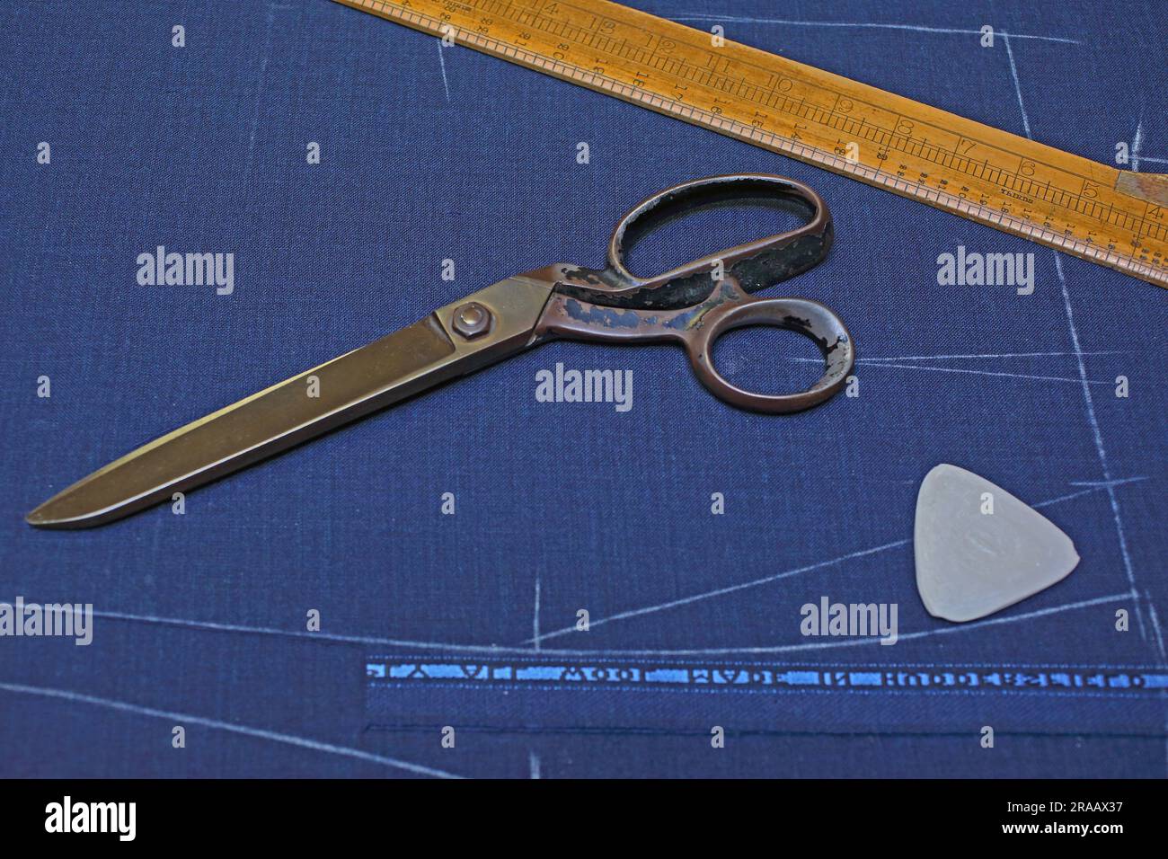 Tailors scissors lying on fabric marked in chalk with the pattern of ...