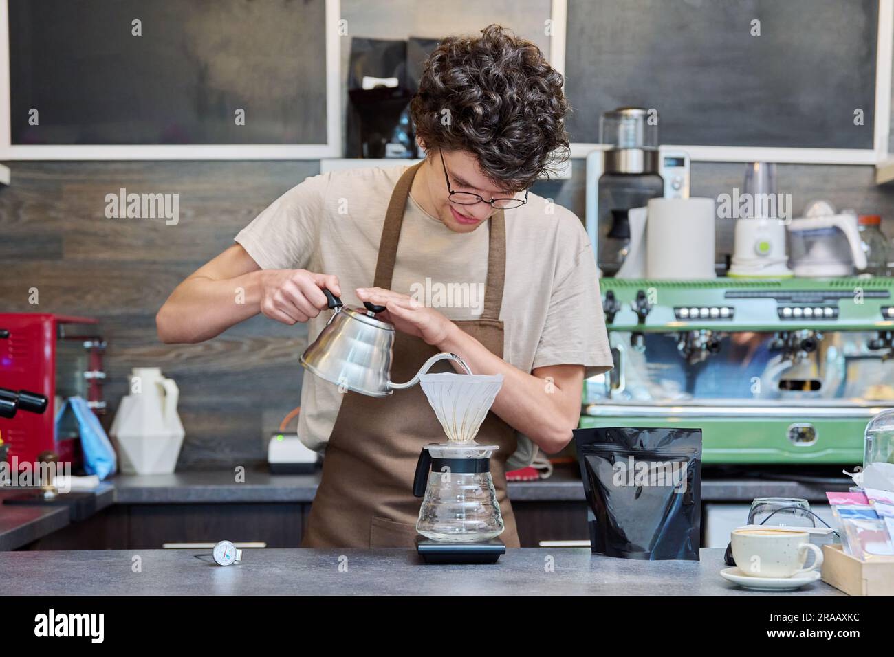 Portrait of young guy barista, worker, at counter in coffee shop Stock ...