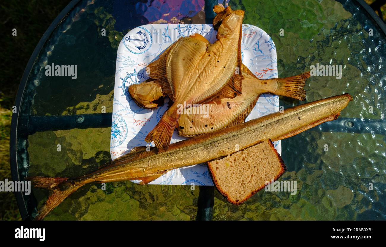 Smoked fish on a paper plate. Delicious home-smoked fish. Two plaice ...