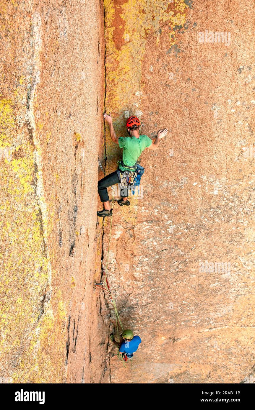 Male rock climber ascends a steep rock face in the Dragoon Mountains ...