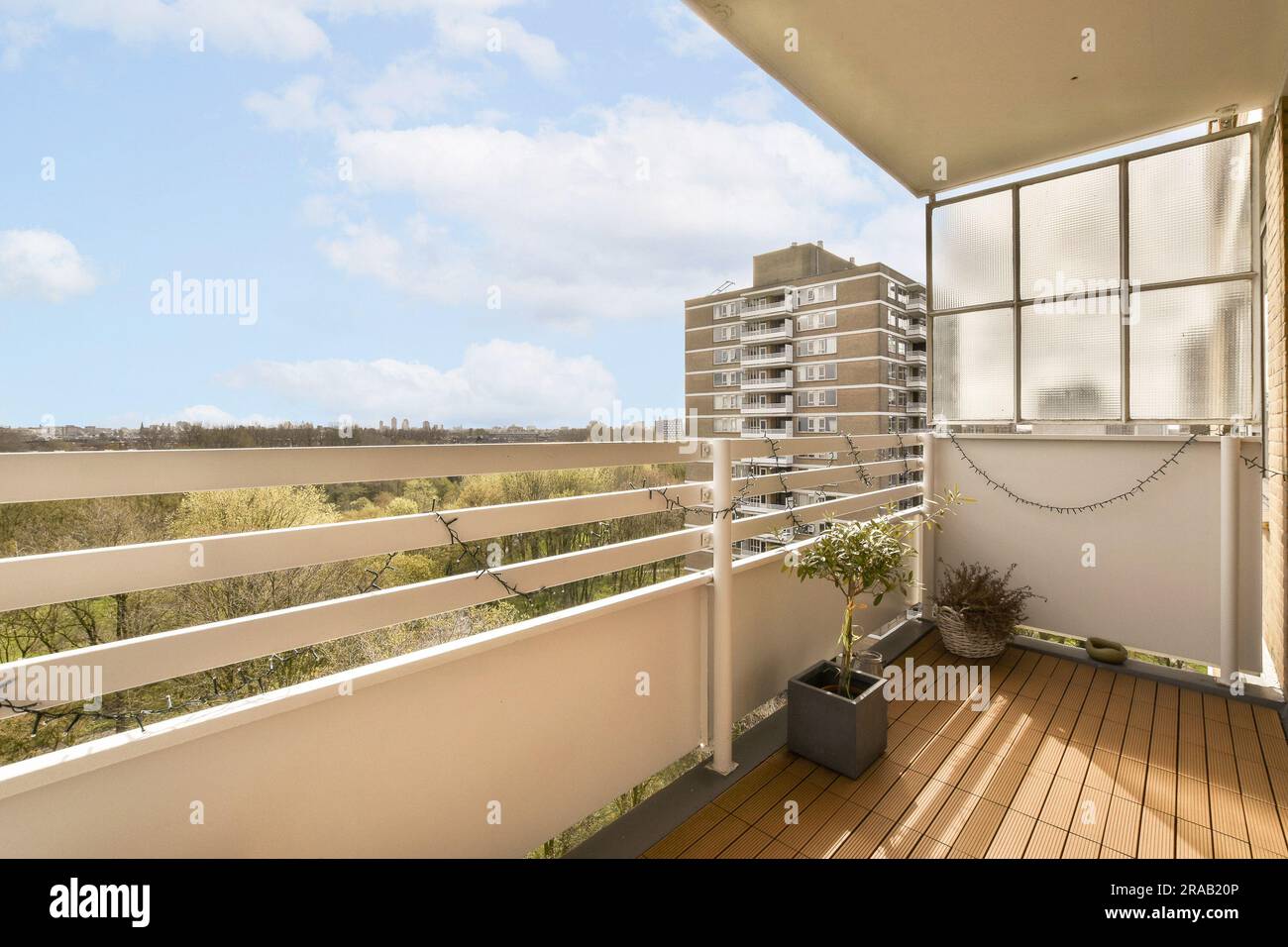 a balcony with some buildings in the background and trees on the other ...