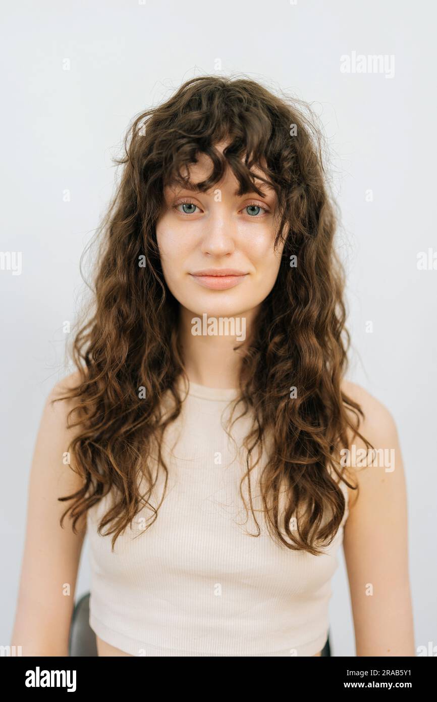 Vertical studio portrait of pretty young woman before applying ...