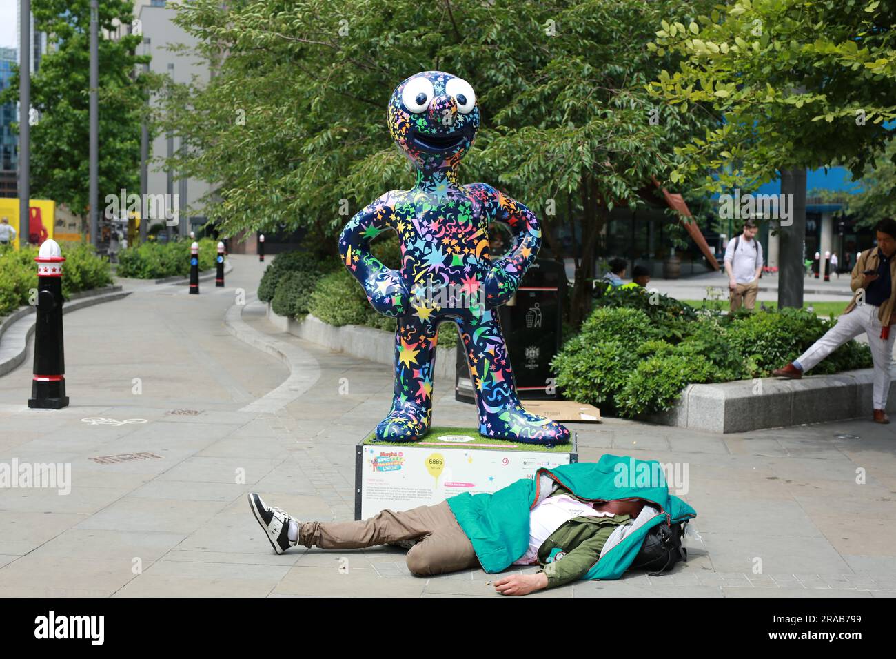London, UK. 02 July 2023. A homeless man sleeps by the sculpture of ...