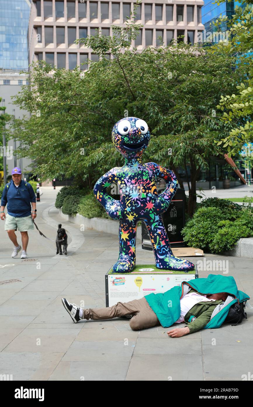 London, UK. 02 July 2023. A homeless man sleeps by the sculpture of ...