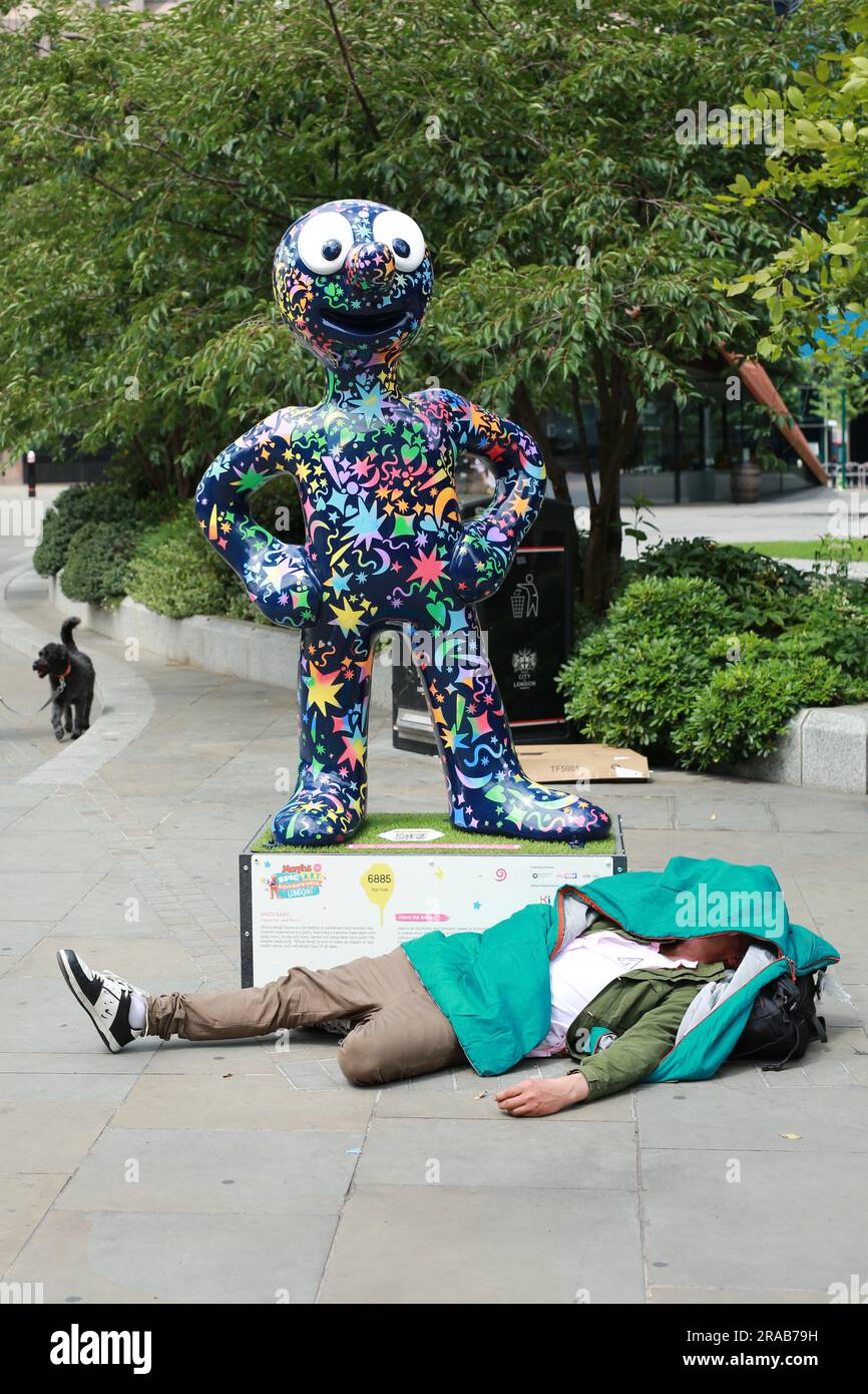 London, UK. 02 July 2023. A homeless man sleeps by the sculpture of ...