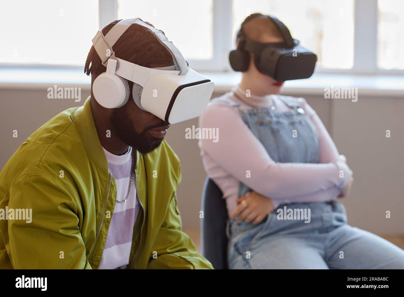 Young people in VR glasses sitting at session and having virtual ...