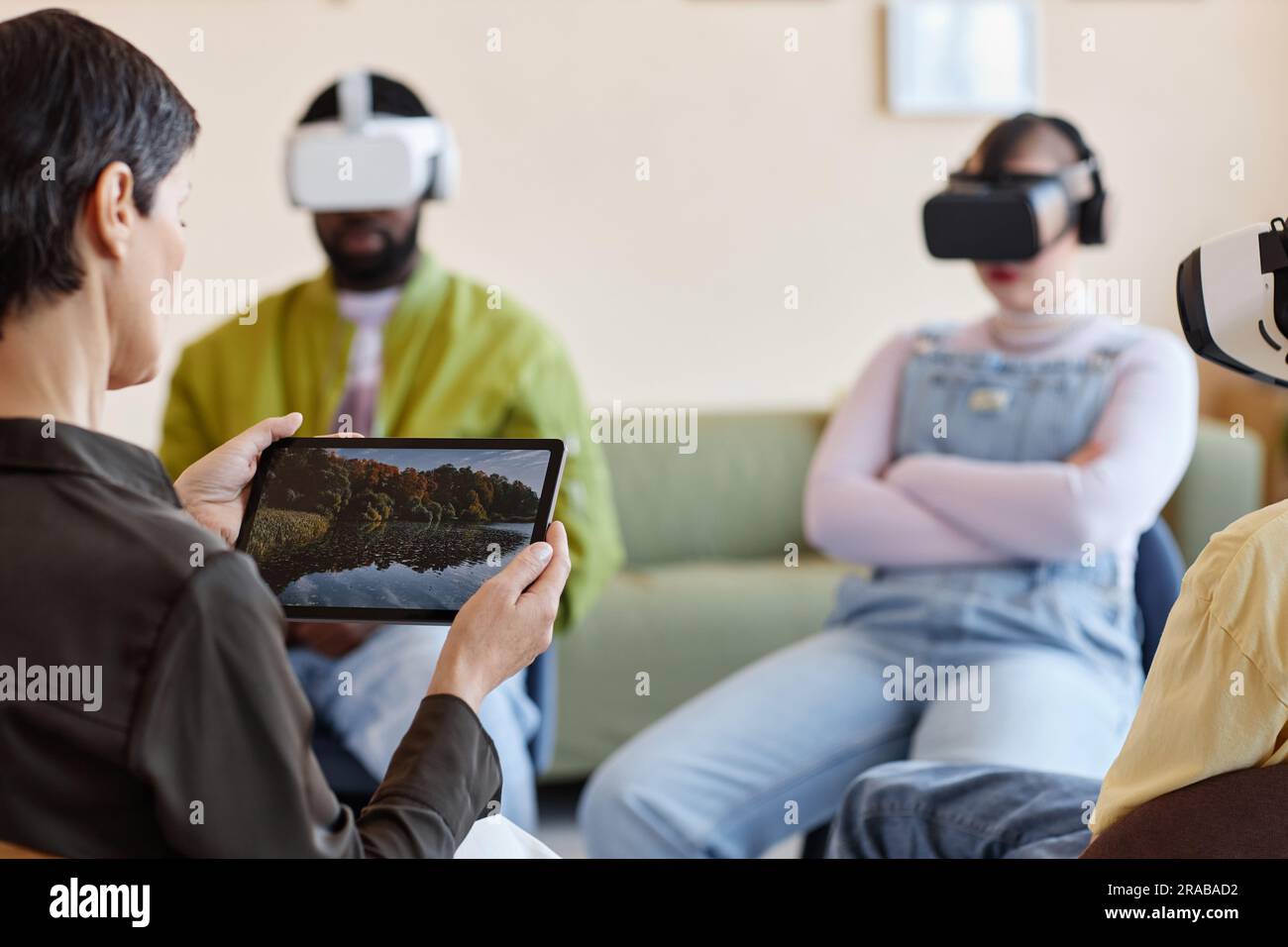Rear view of psychologist using digital tablet to conduct virtual ...