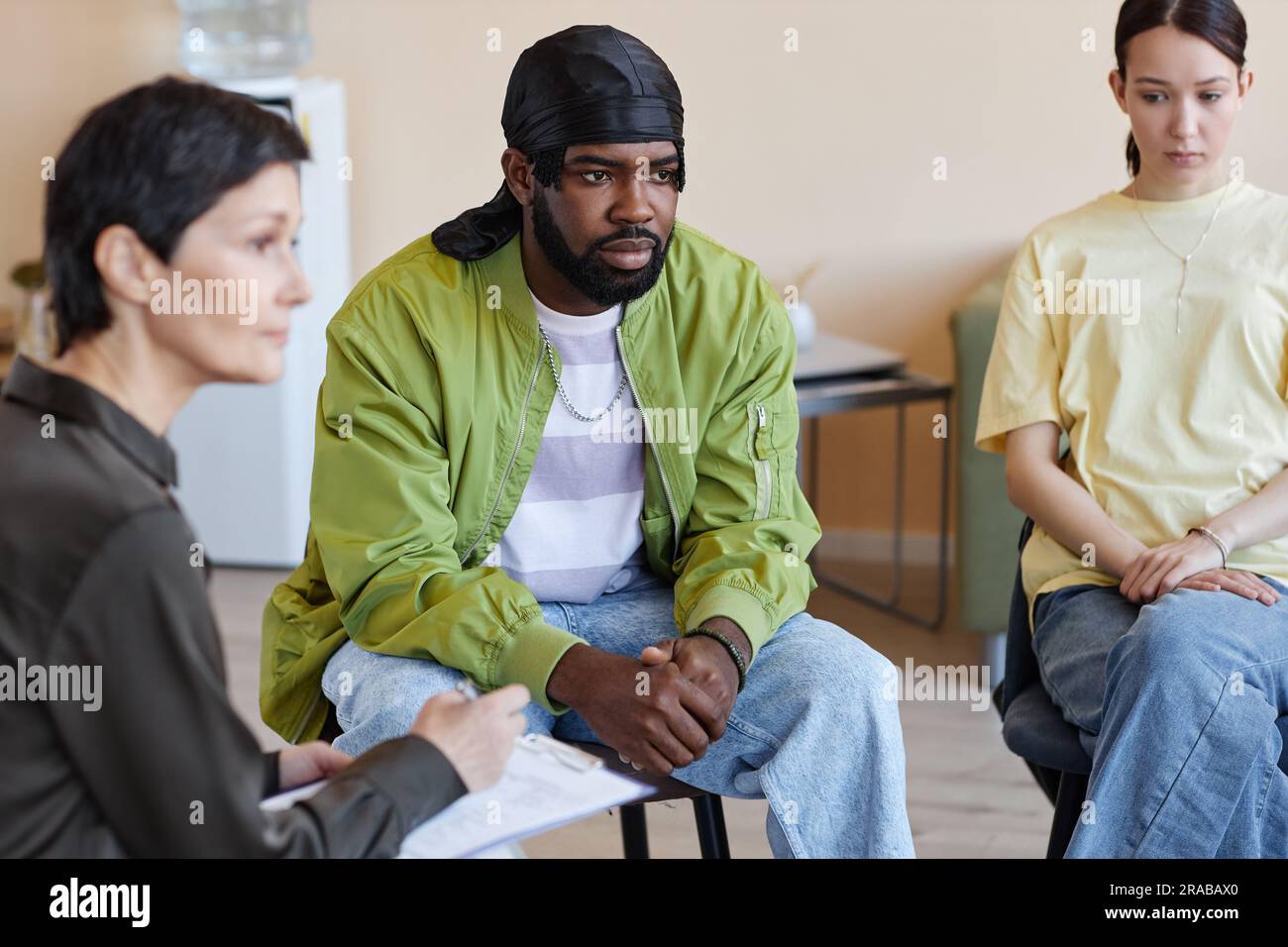 Group of people sitting together at session and talking to each other ...