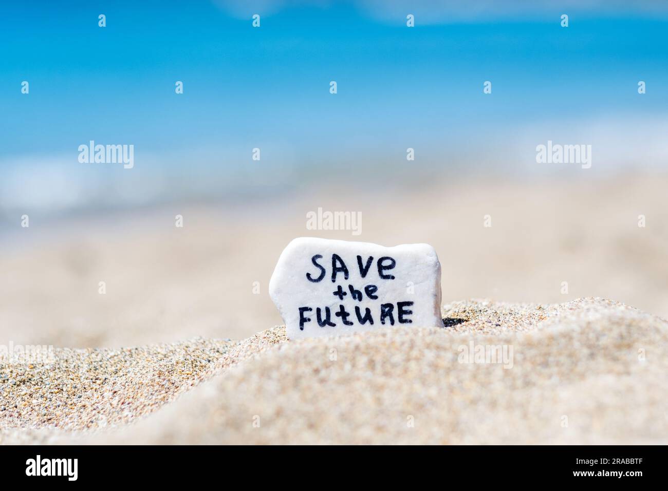 Save the future the words drawing on a stone in the sand on the beach ...