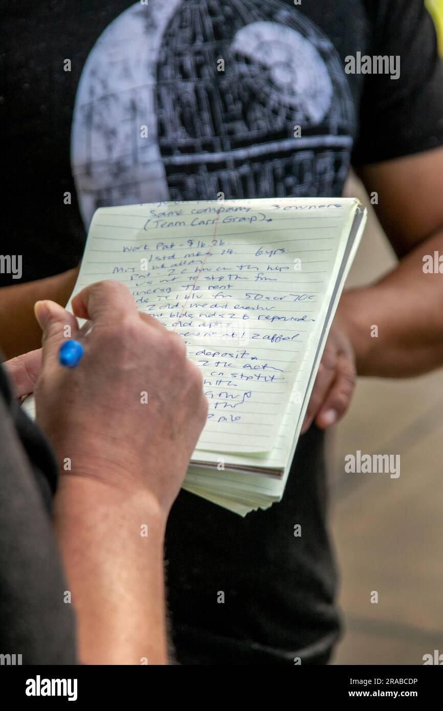 Taking down quotes in a spiral notebook, a newspaper reporter ...