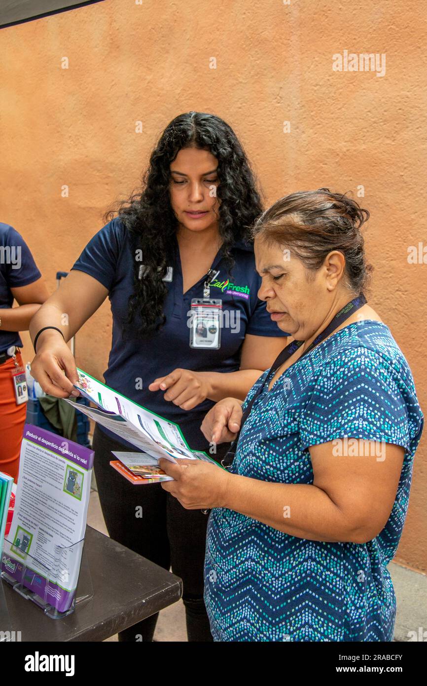 A middle aged Hispanic woman chats with a nutrition counselor at an ...