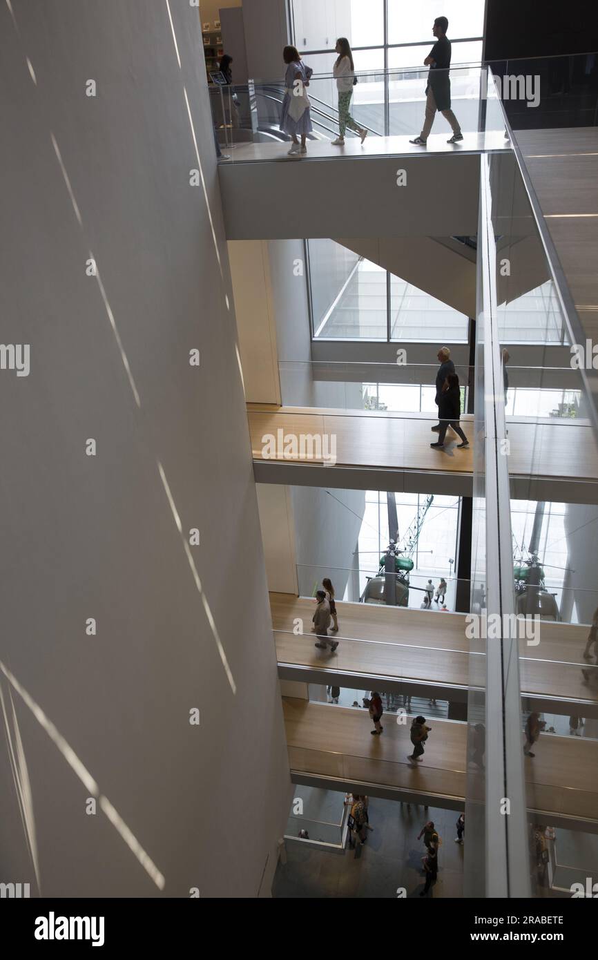 Museum goers traversing different floors in the open interior design at ...