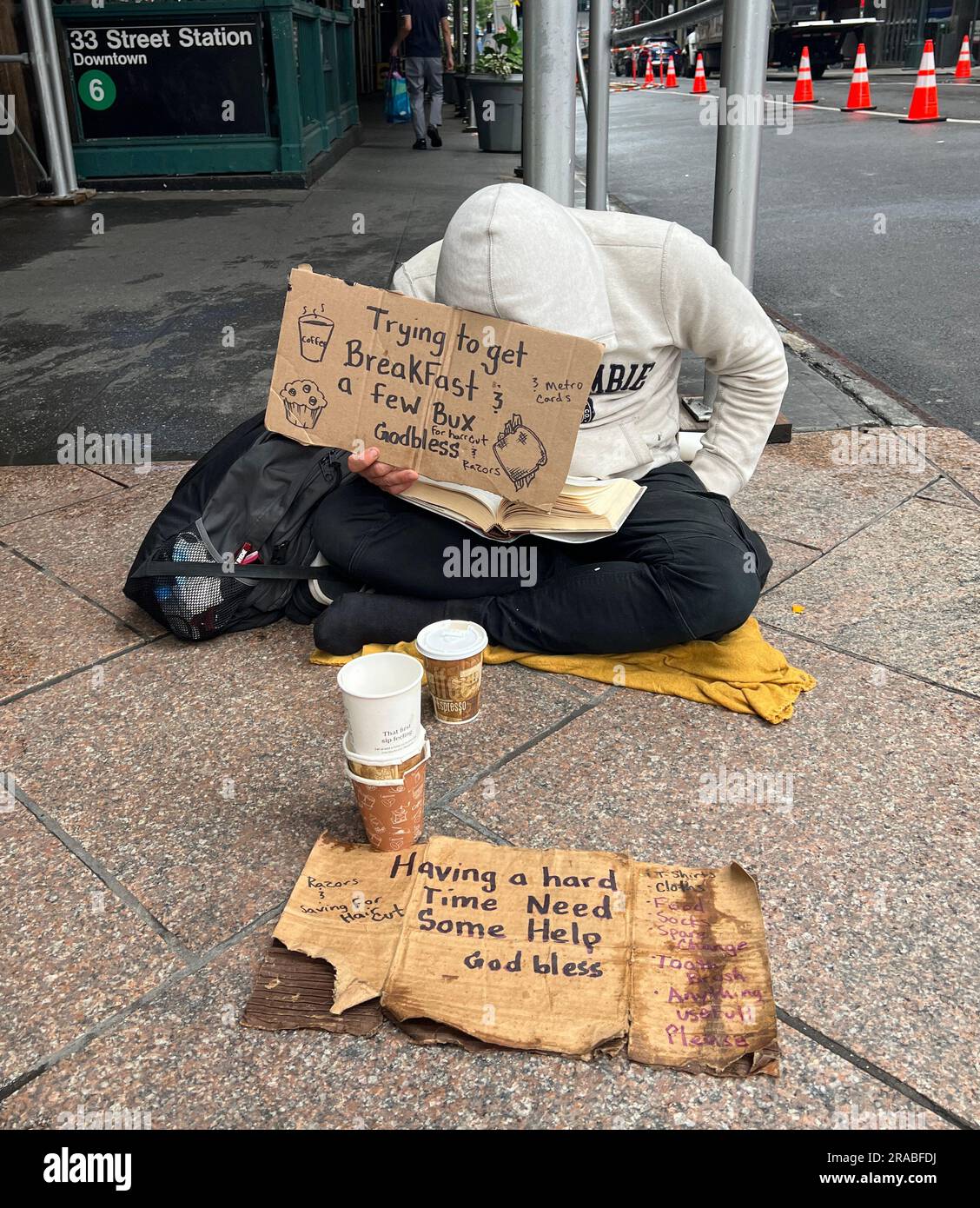 Homeless man reaches out sitting on the sidewalk on Park Avenue South ...