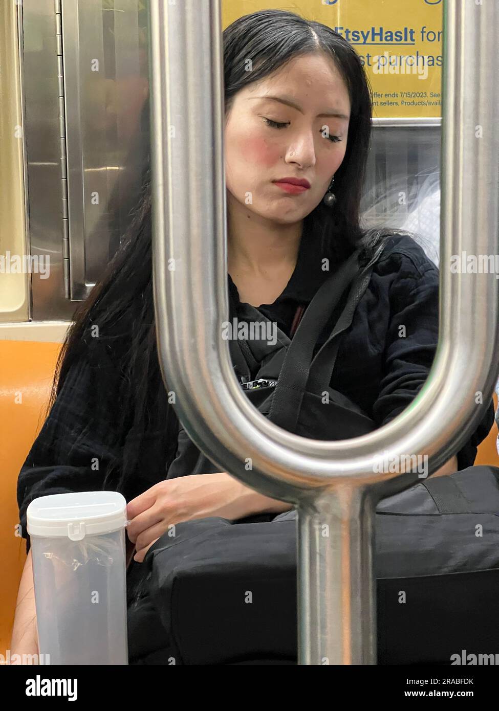 Woman rests as she rides a subway train in Brooklyn, New York Stock ...
