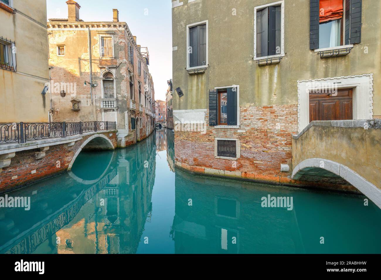 Canal with stone bridges and historic buildings in Venice, Italy ...