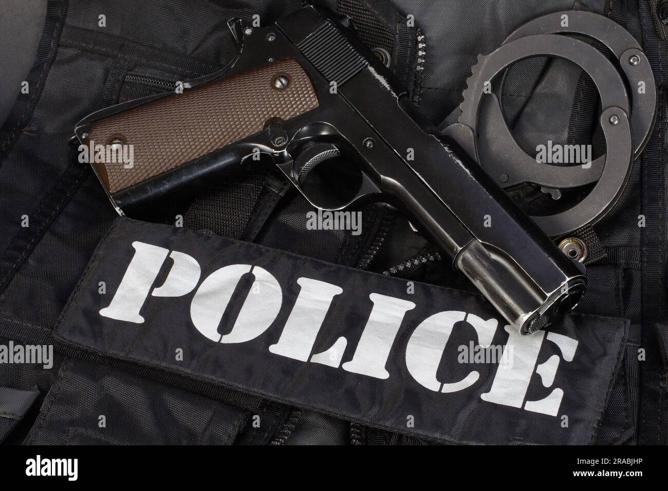 Police handgun with handcuffs on black uniform background Stock Photo ...