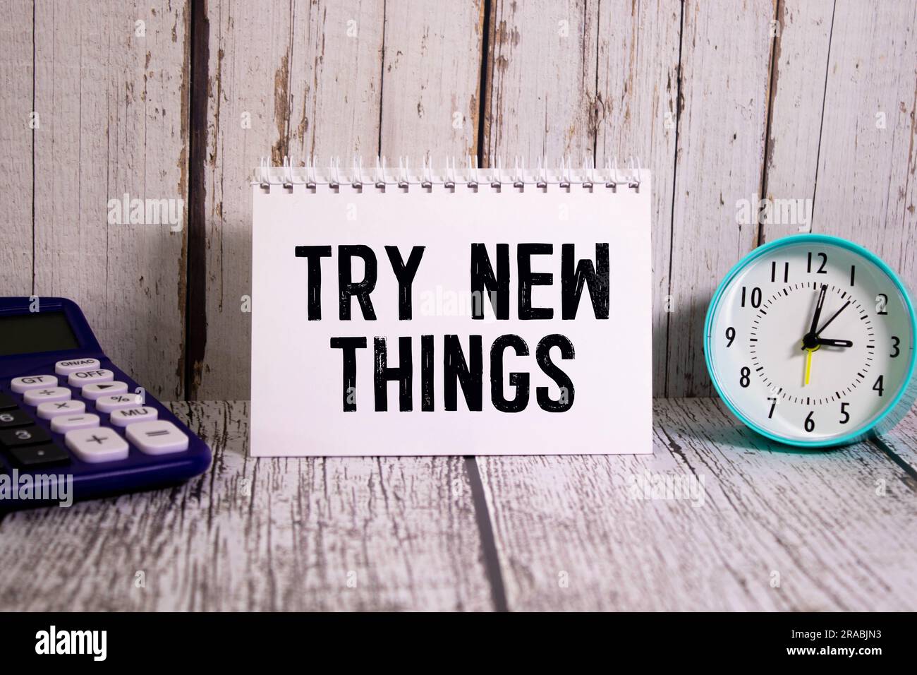 Yellow blank notepad on office wooden table Try something new concept ...