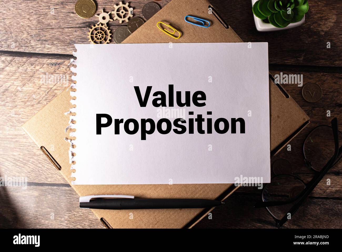 On a light brown background, blue and red pencils and white paper with ...