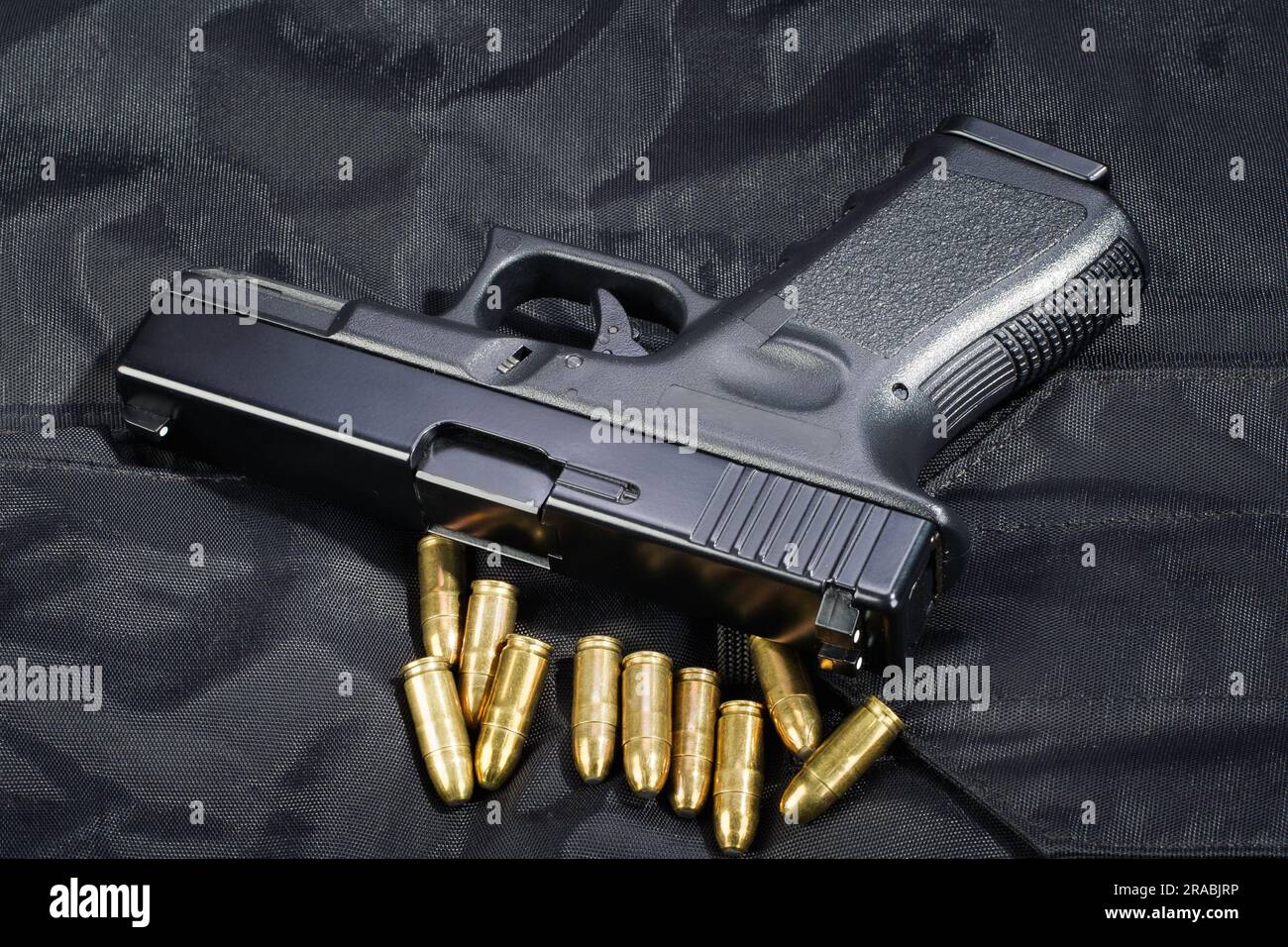 Police hand gun on black uniform background Stock Photo - Alamy