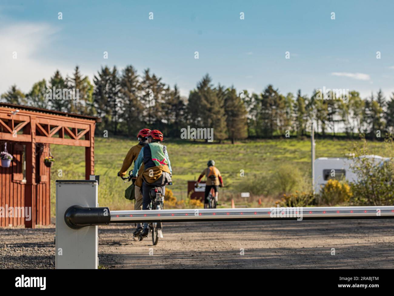 Three people on bicycles rust gone through and electronic a barrier ...