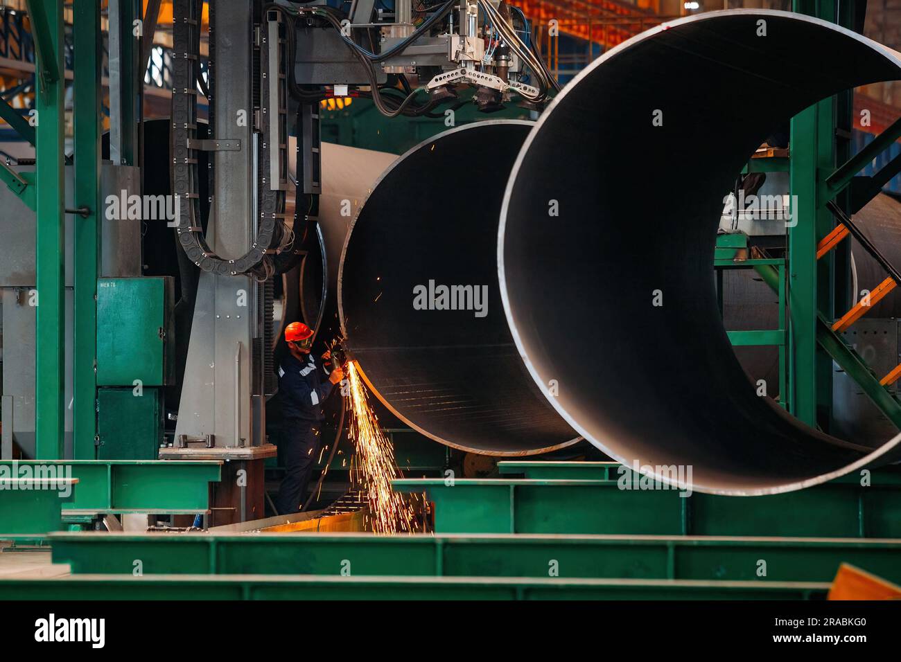 Worker cleans welded seam on steel pipe using grinding machine Stock ...