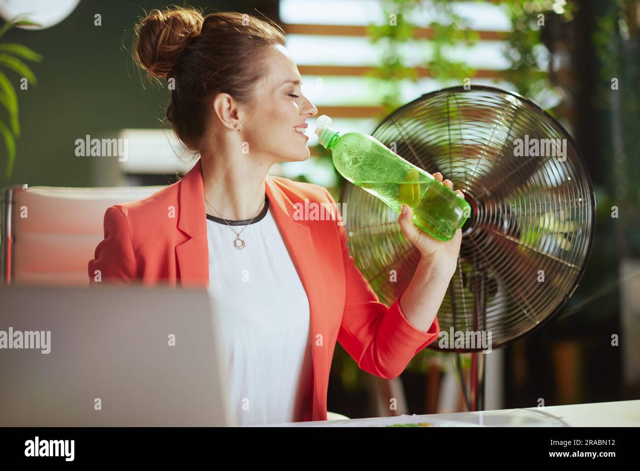 Sustainable workplace. happy modern female employee at work in red ...