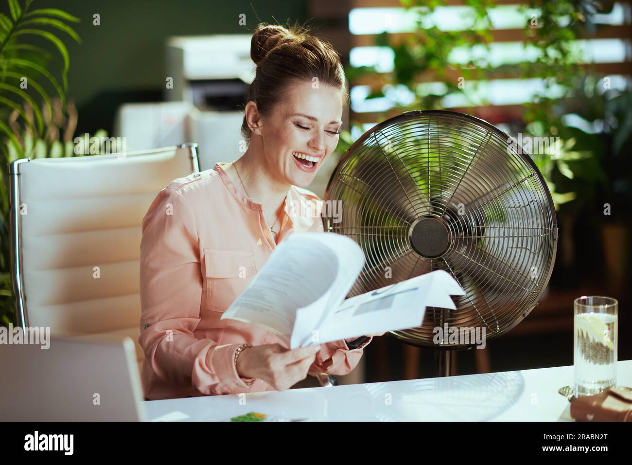 Sustainable workplace. happy modern woman worker at work with documents ...