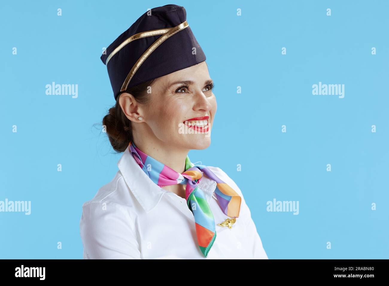 smiling modern female air hostess against blue background in uniform ...