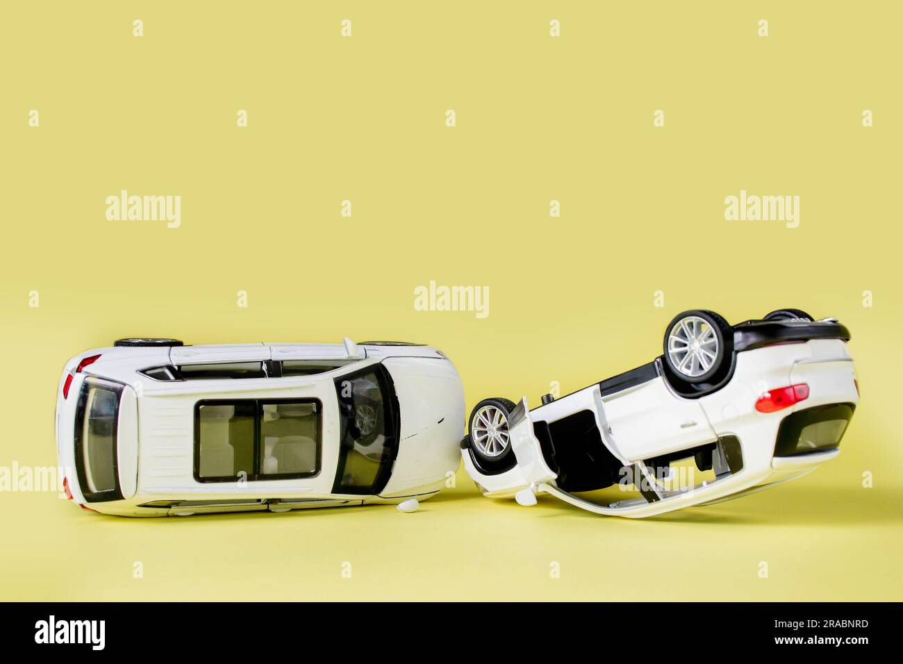 Two mini toy car crash on yellow background, incident, car traffic ...