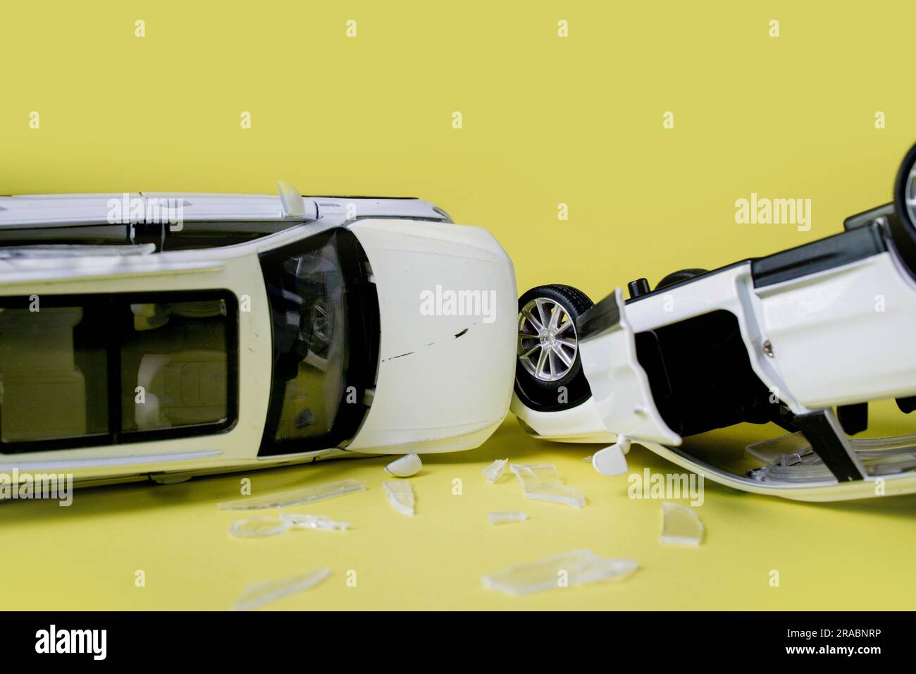 Two mini toy car crash on yellow background, incident, car traffic ...
