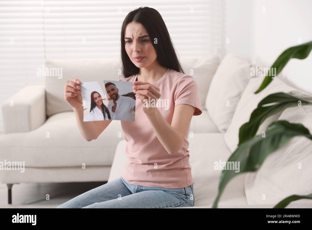 Upset woman ripping photo at home. Divorce concept Stock Photo - Alamy