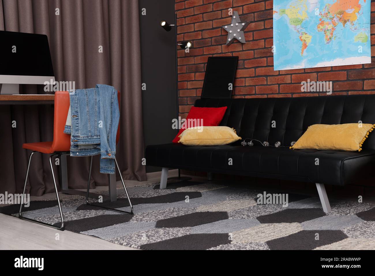 Stylish teenager's room with computer, black sofa and world map on ...