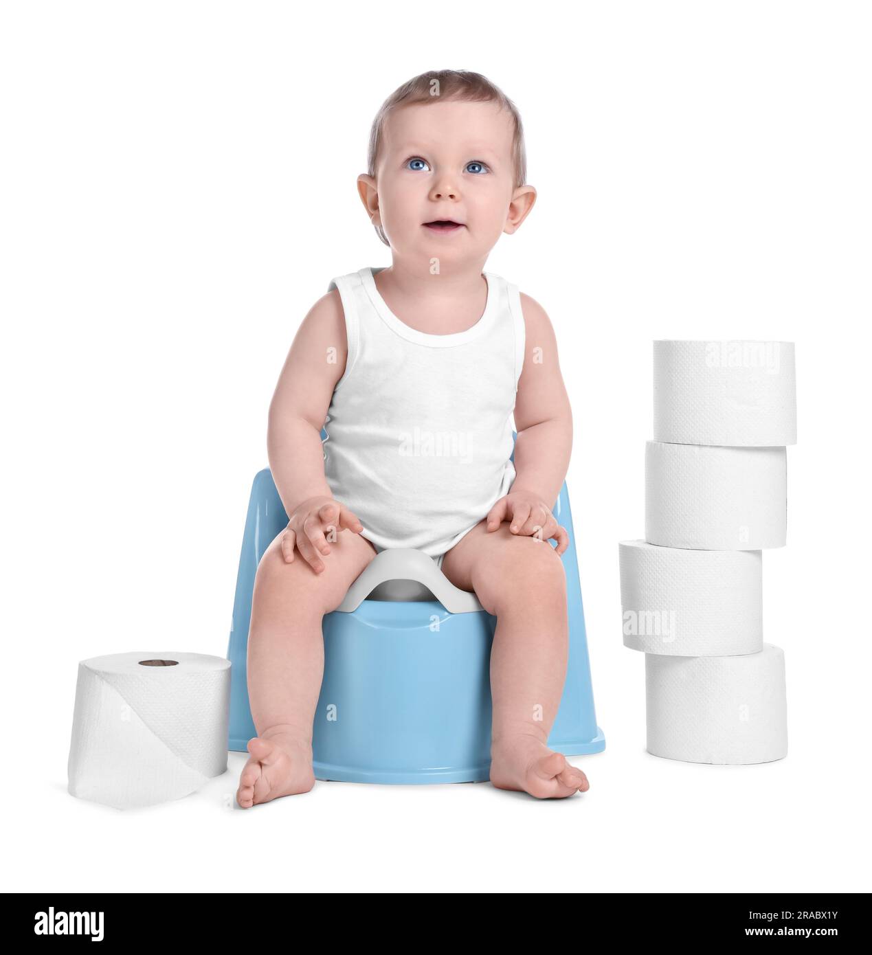 Little child sitting on baby potty and stack of toilet paper rolls ...