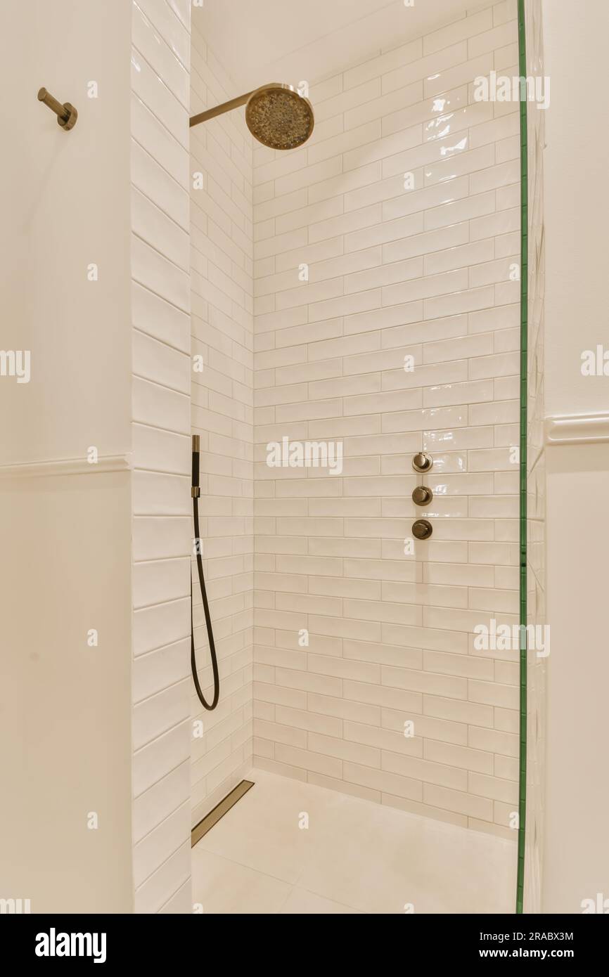 a walk in shower with white subway tile and green trim around the ...