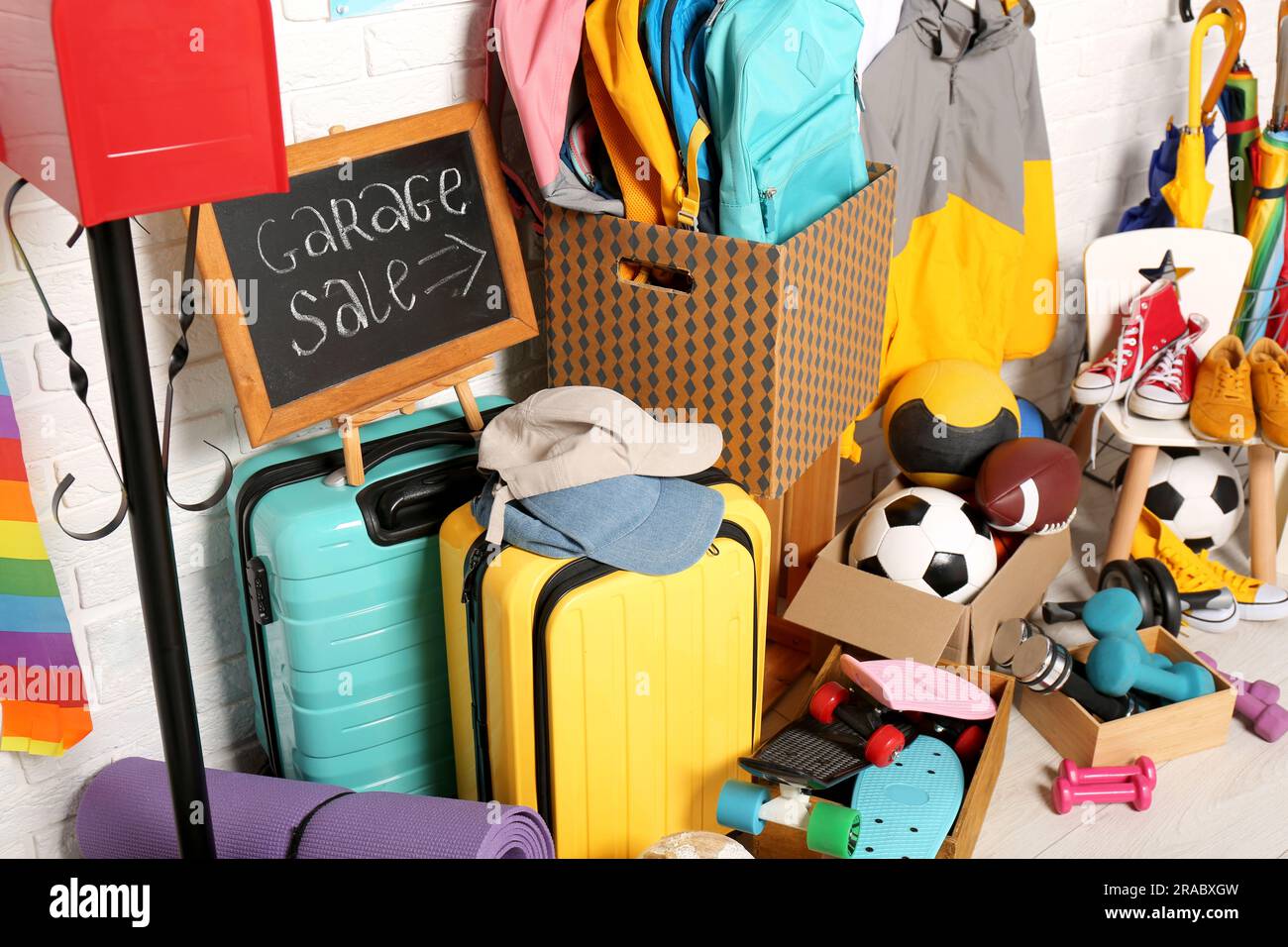 Many different stuff near white brick wall. Garage sale Stock Photo - Alamy
