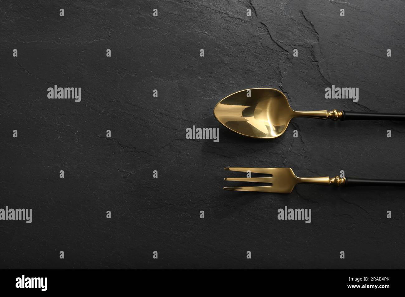 Shiny fork and spoon on black table, flat lay. Space for text Stock ...