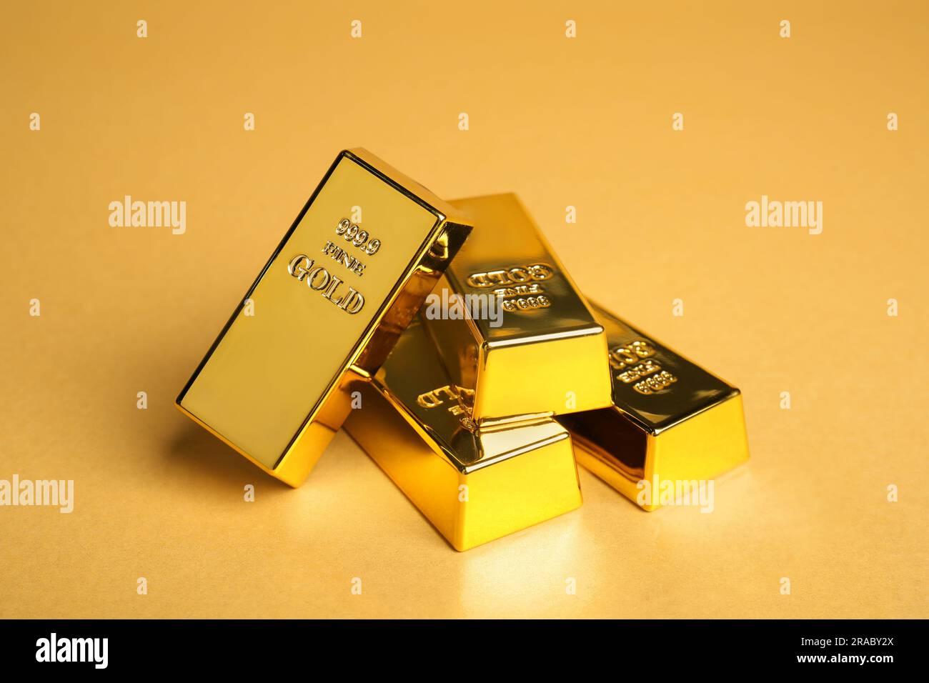 Many shiny gold bars on pale orange background Stock Photo - Alamy