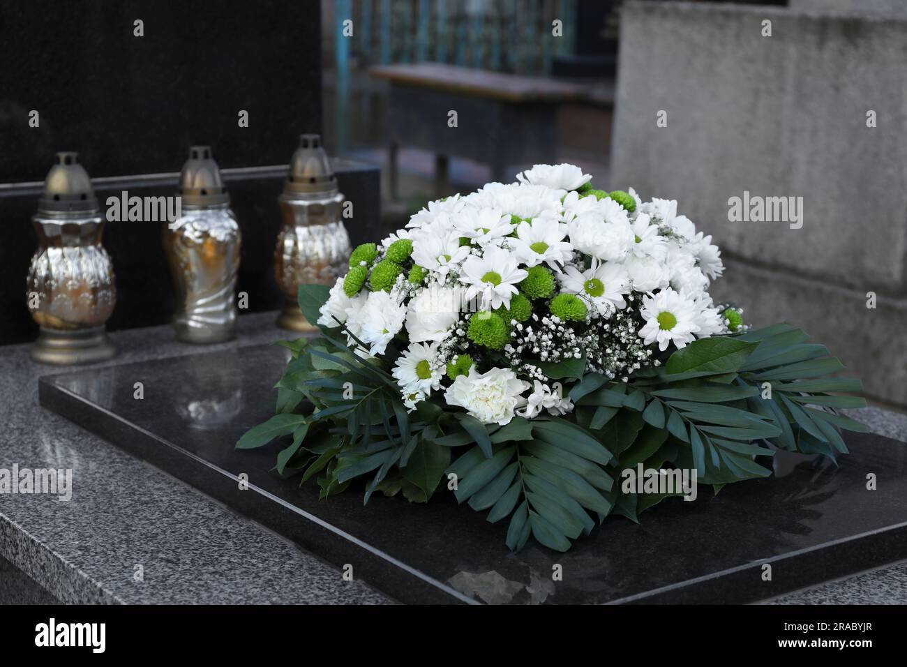 Funeral wreath of flowers and grave lanterns on granite tombstone in cemetery Stock Photo - Alamy