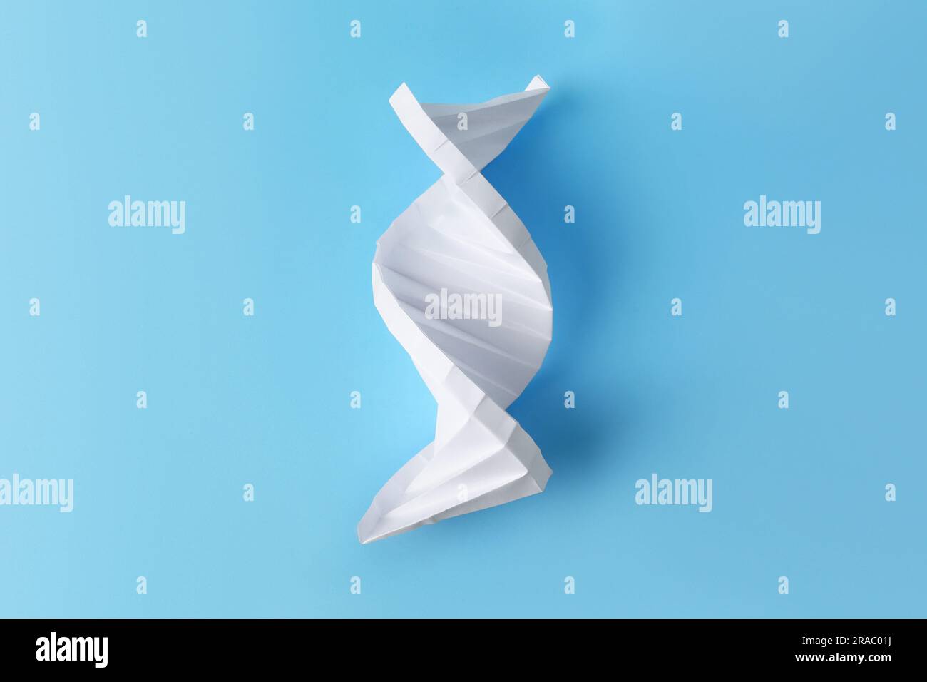 DNA molecule model made of white paper on light blue background, top ...