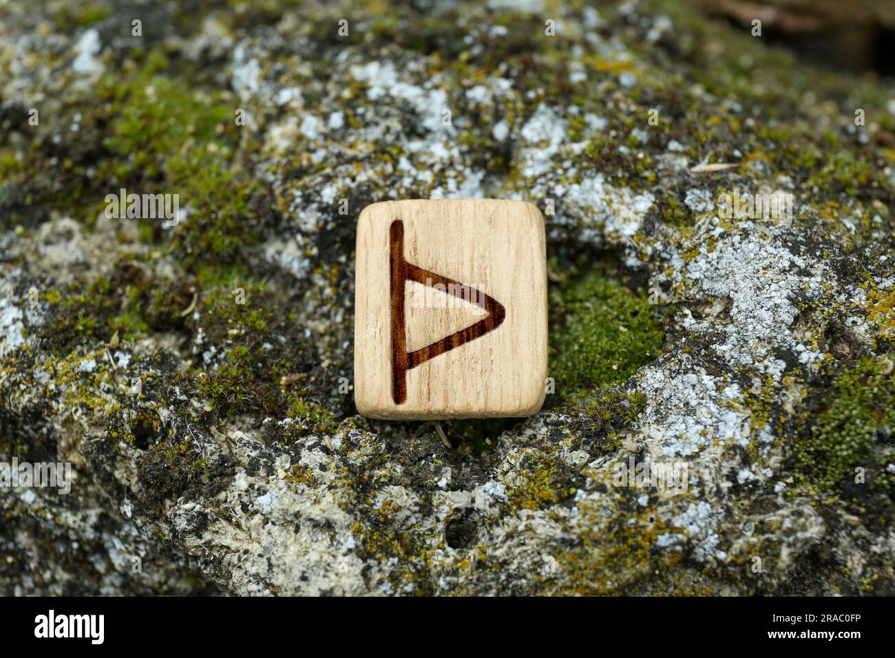 Wooden rune Thurisaz on stone with moss outdoors, closeup Stock Photo ...