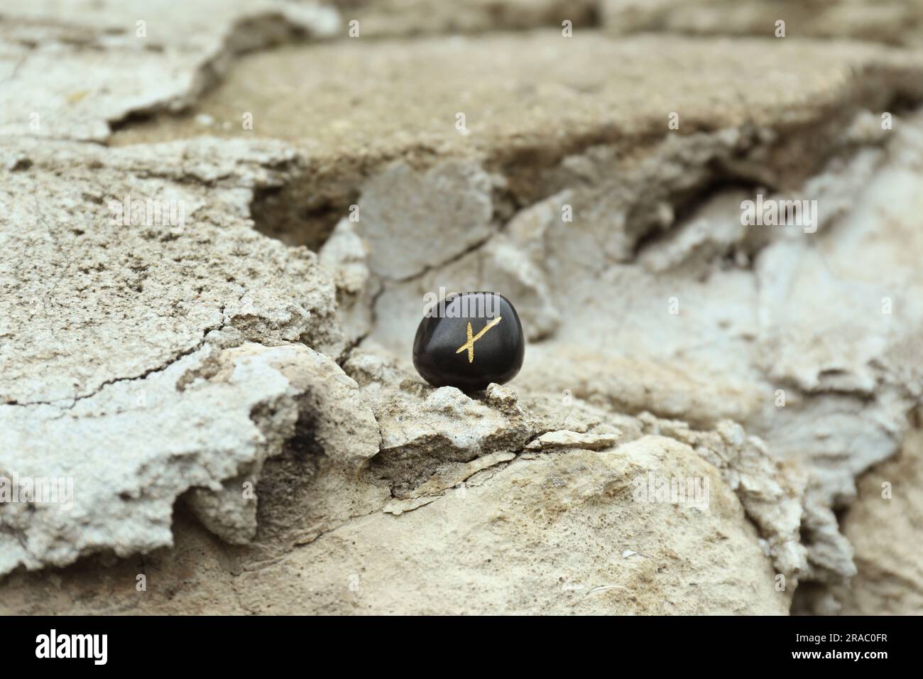 Black rune Nauthiz on stone outdoors. Old Germanic alphabet Stock Photo ...