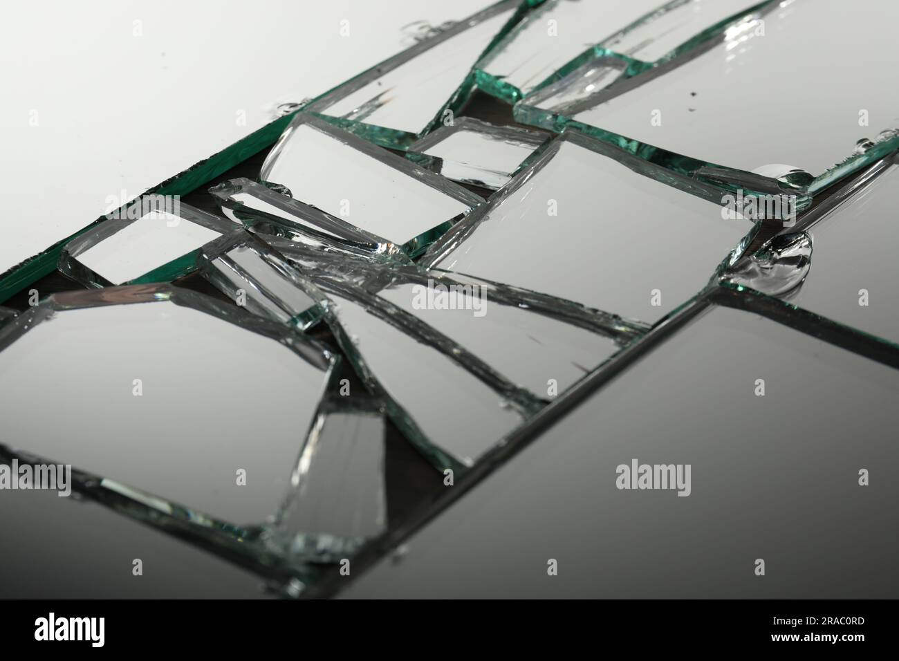 Shards of broken mirror on backing board, closeup Stock Photo - Alamy