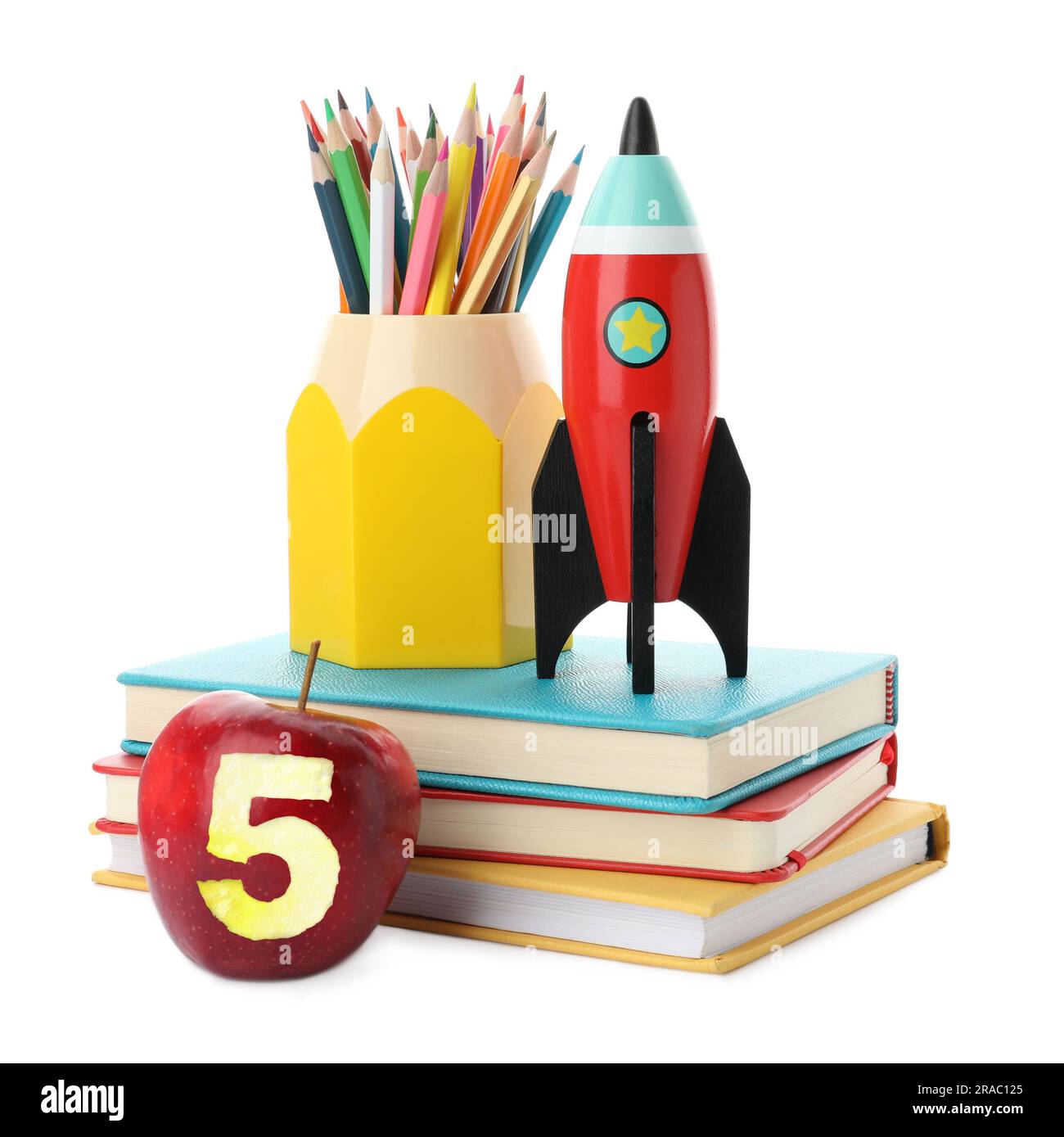 Apple with carved number five as grade. Bright toy rocket and school ...