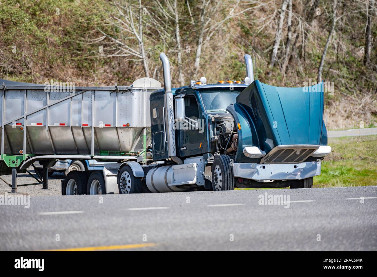 Industrial dark green broken big rig day cab semi truck with open hood ...