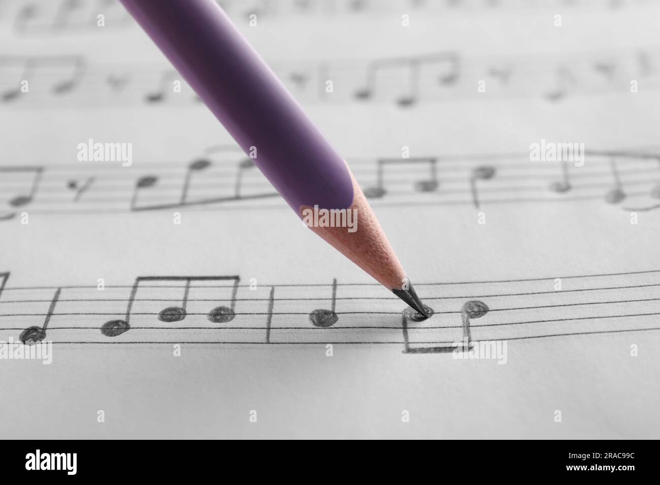 Writing musical notes with pencil on sheet of paper, closeup view Stock ...